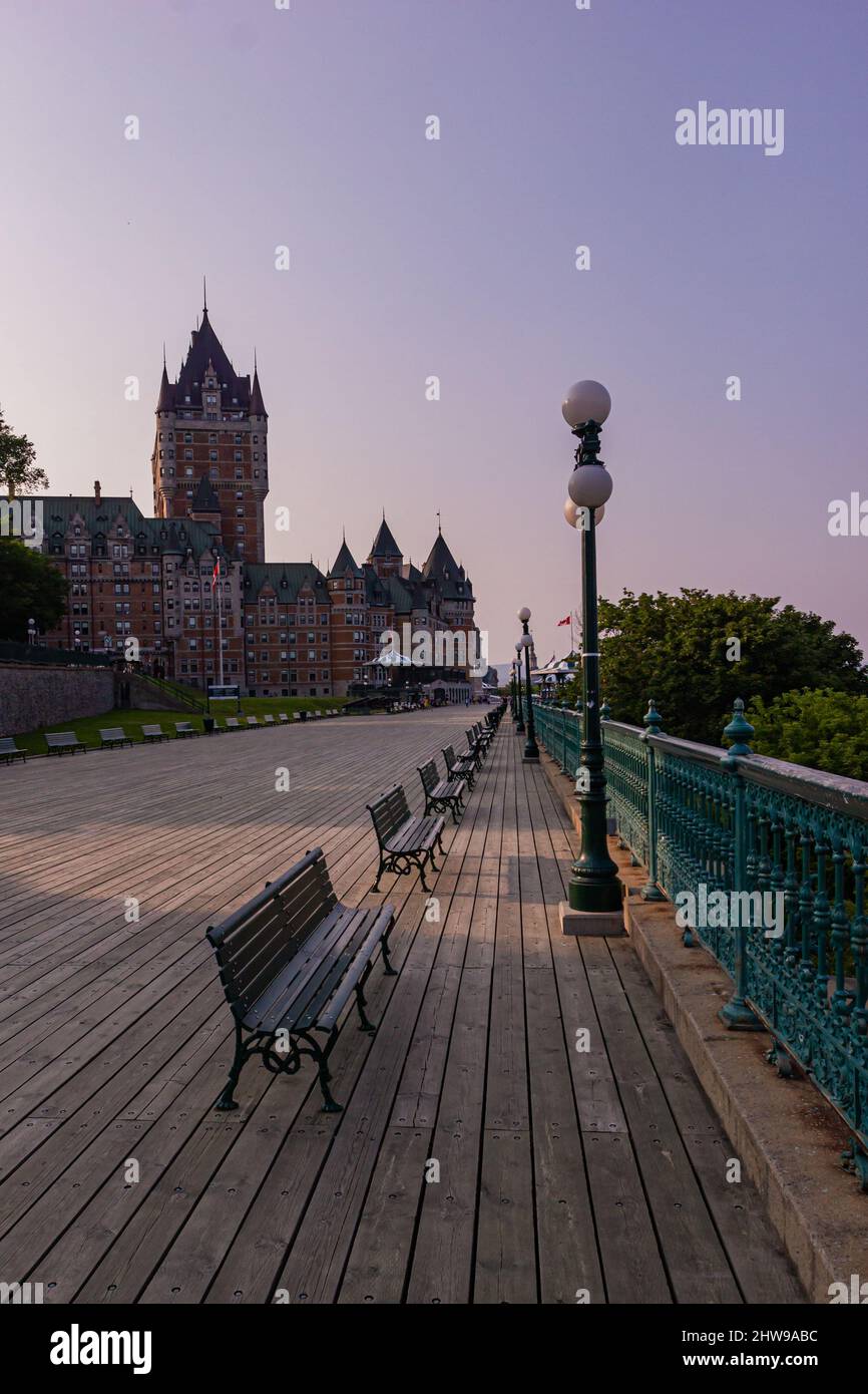 Park benches line a wooden boardwalk in front of the majestic colonial ...