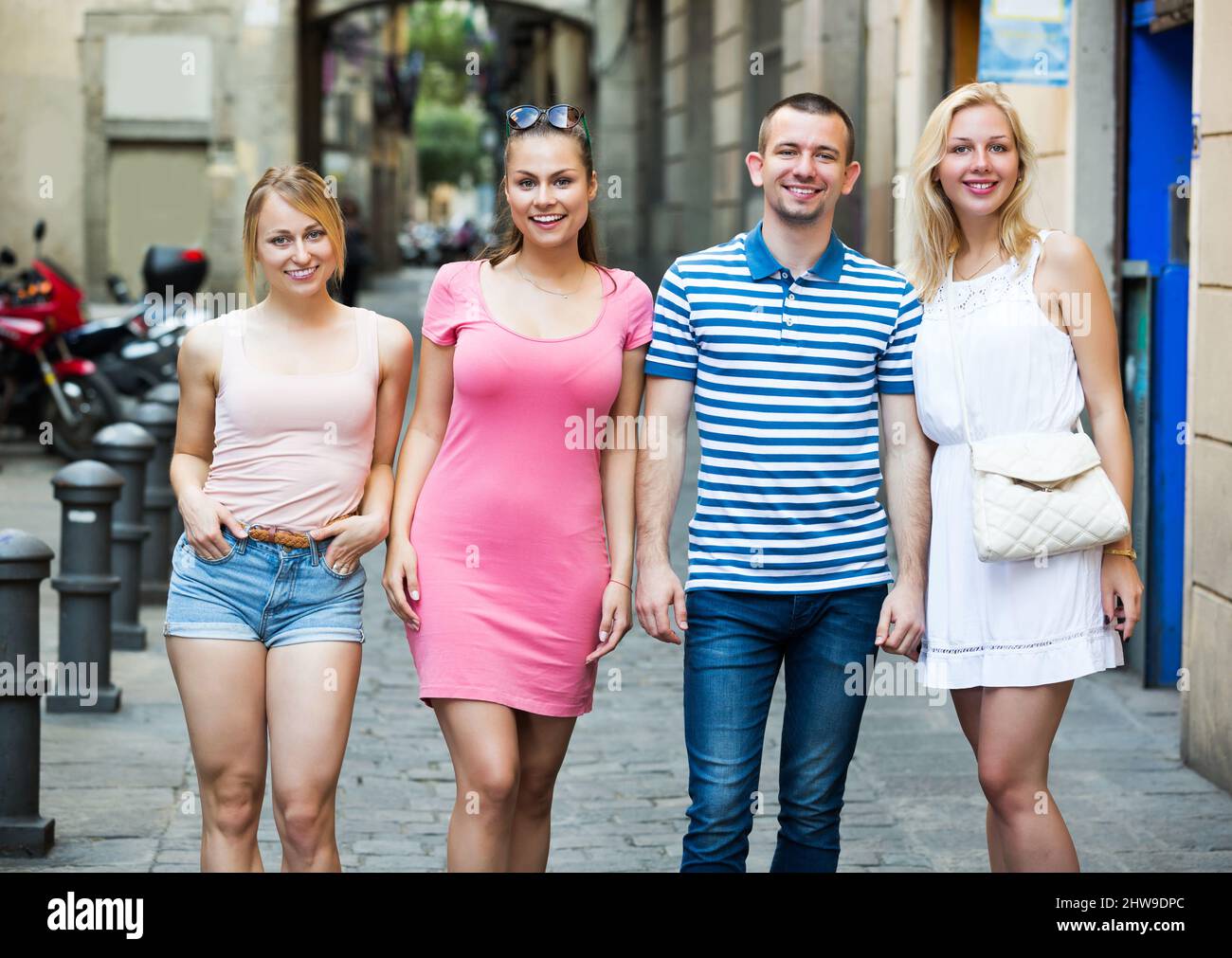 Four smiling persons walking together Stock Photo - Alamy
