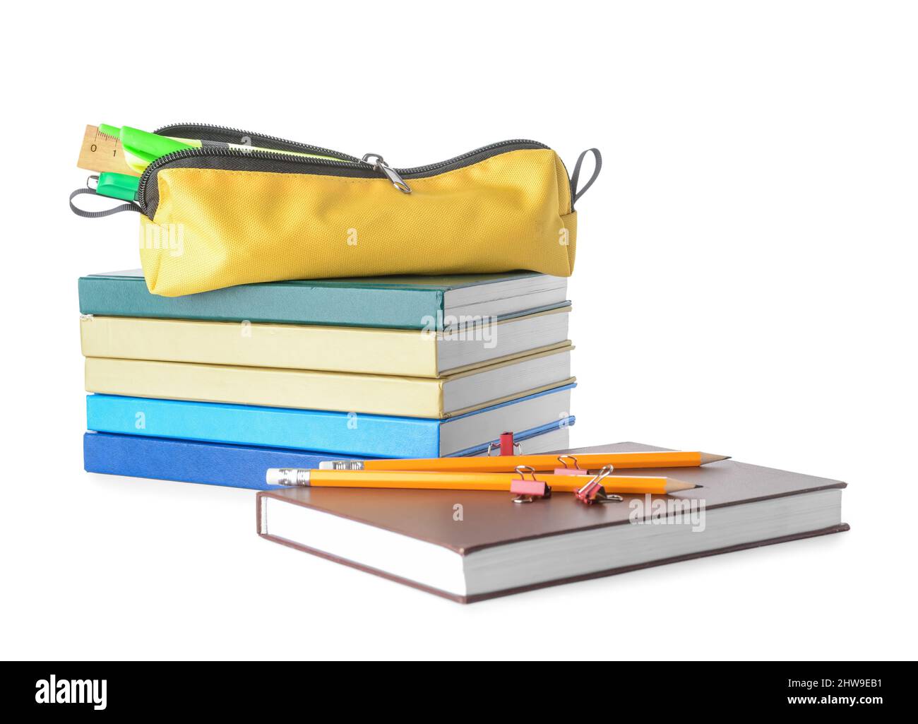 Stack of books and pencil case with stationery on white background ...