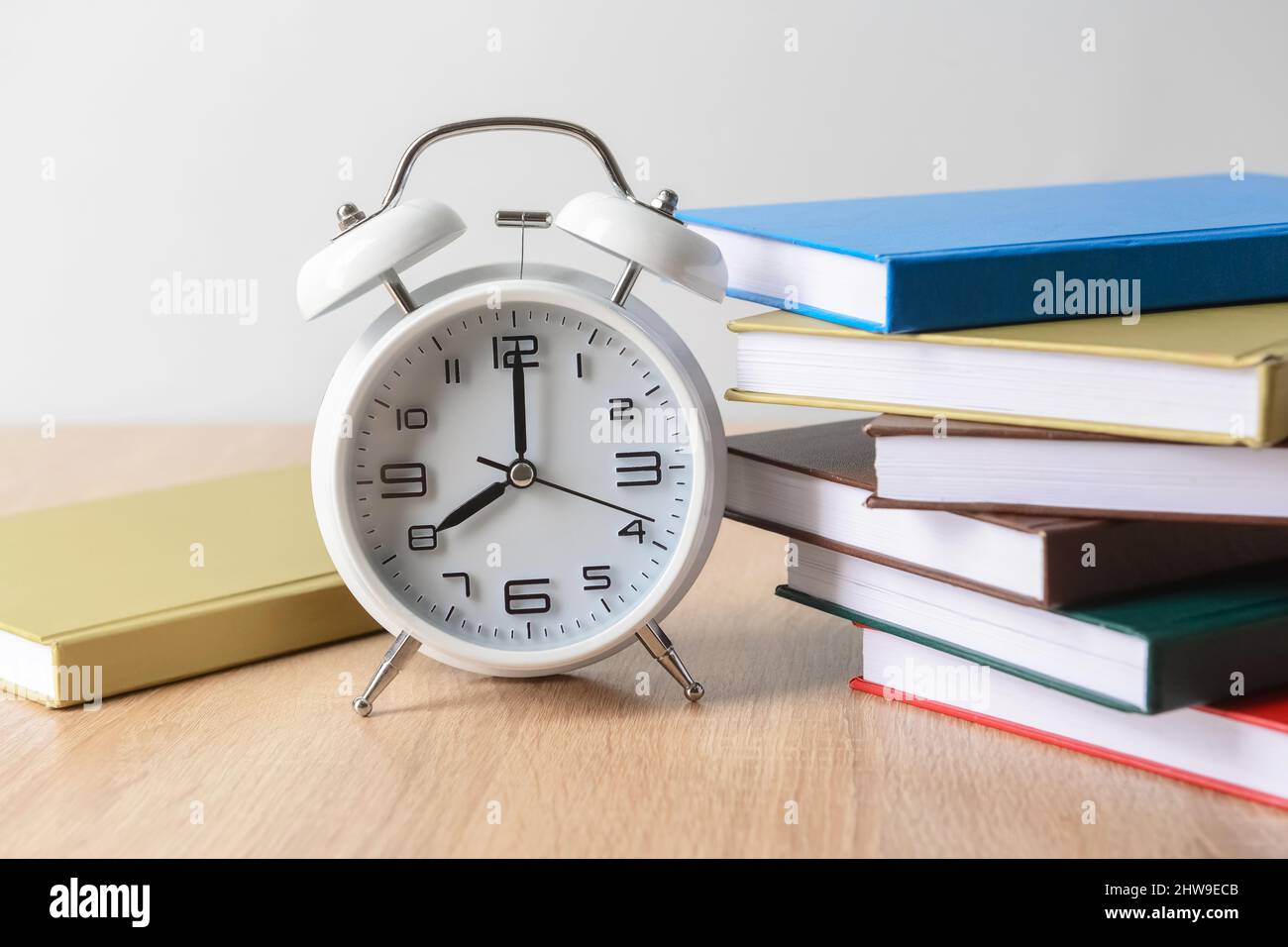 Stack of books and alarm clock on table, closeup Stock Photo - Alamy