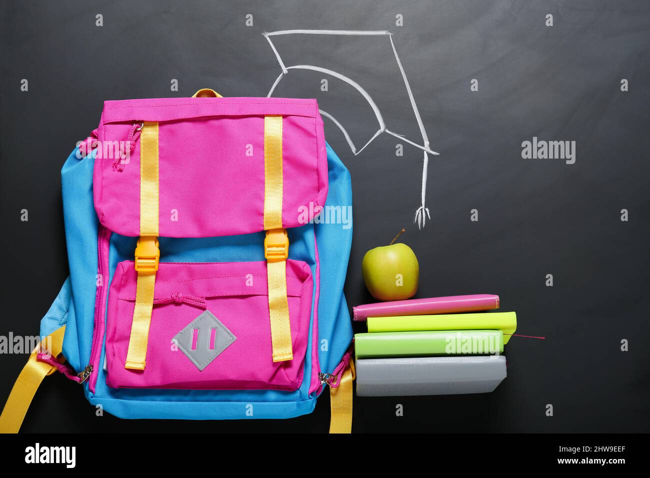 Composition with school backpack, notebooks and apple on dark ...