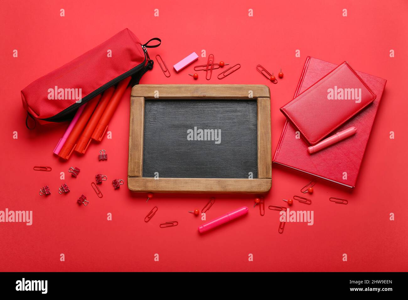 Composition with chalkboard and stationery on red background Stock ...