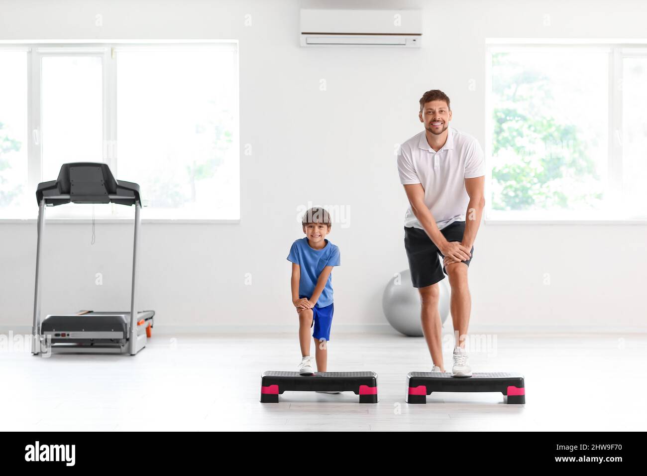 Little boy and his coach training with steppers in gym Stock Photo - Alamy