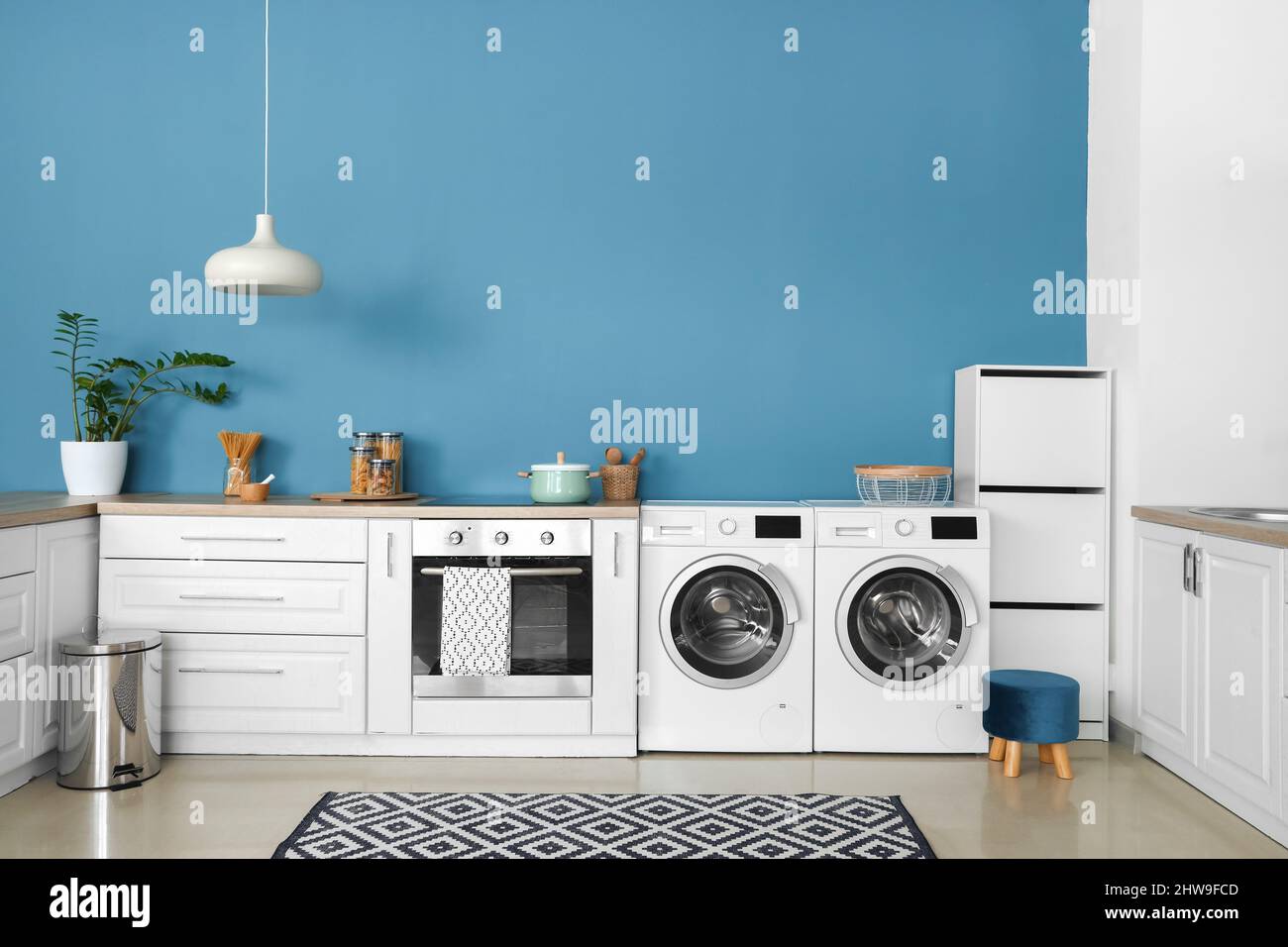 Interior of stylish kitchen with modern washing machines, oven and ...
