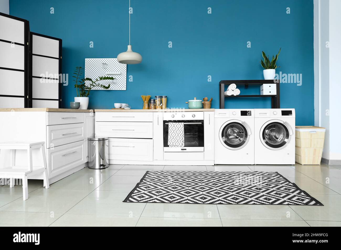 Interior of stylish kitchen with modern washing machines, oven and ...