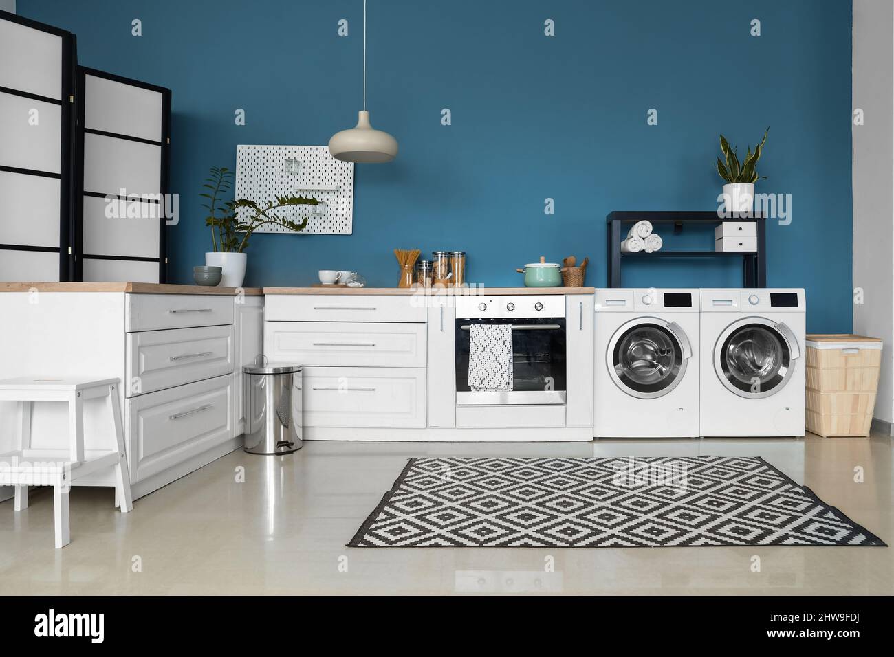 Interior of stylish kitchen with modern washing machines, oven and ...