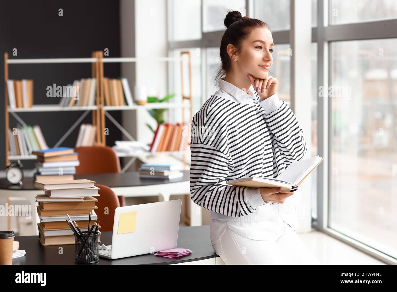 Beautiful young woman studying in library Stock Photo - Alamy