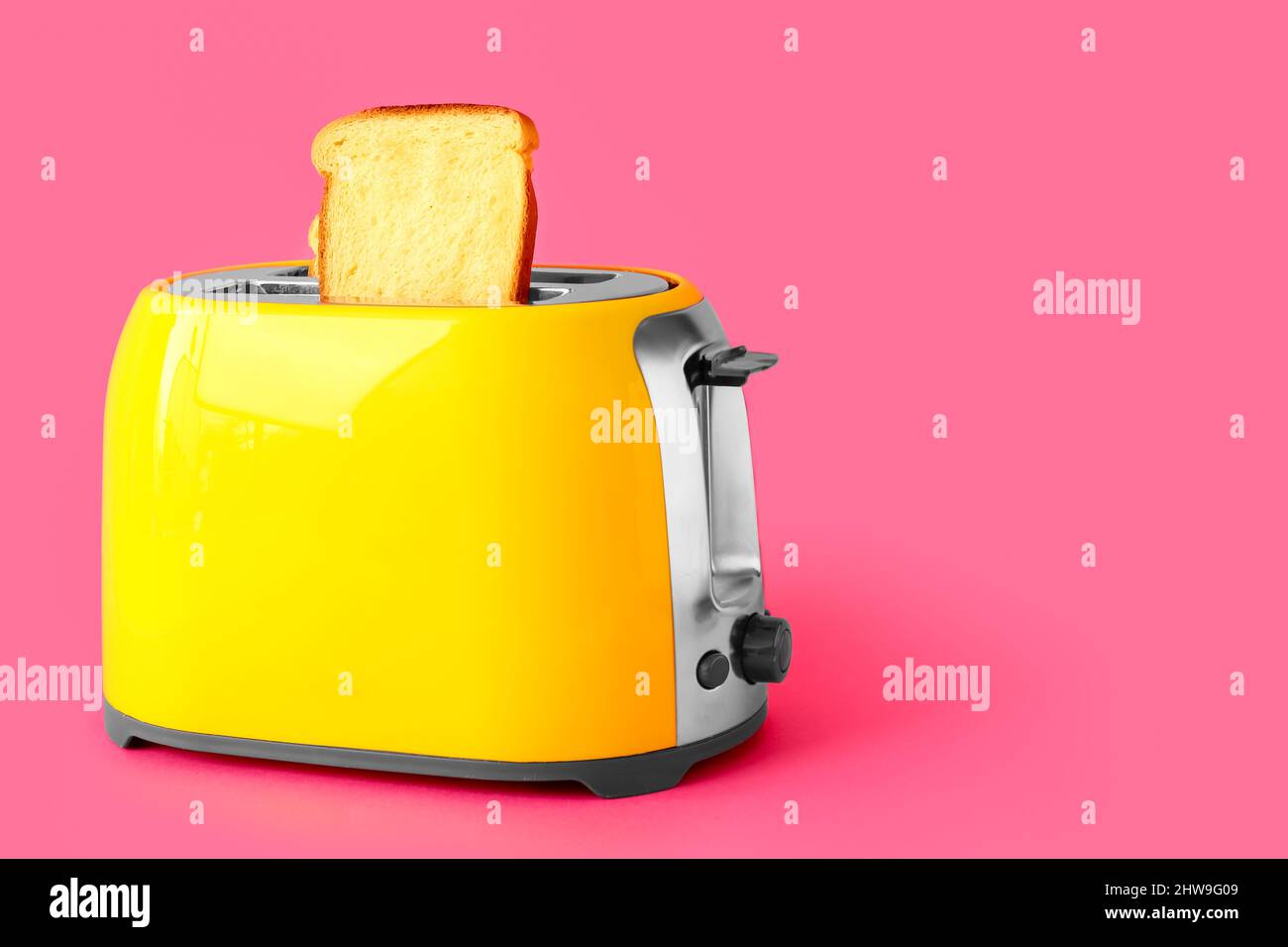 Modern toaster with bread slice on pink background Stock Photo - Alamy