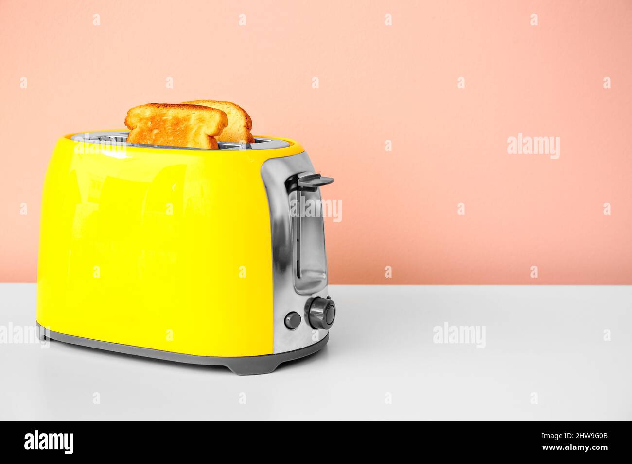 Modern toaster with bread slices on table Stock Photo - Alamy