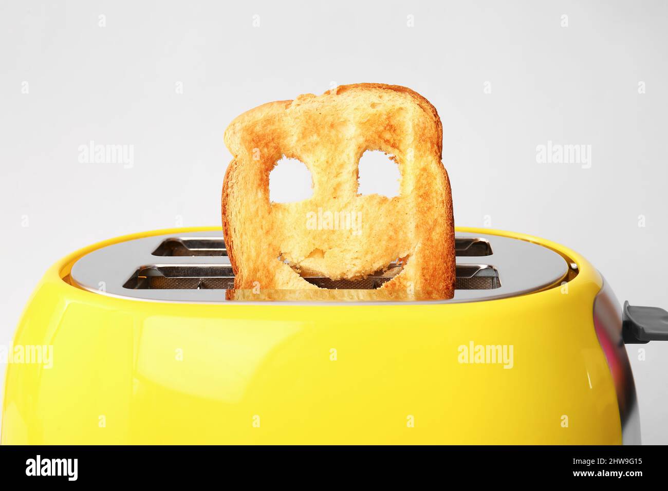 Funny slice of bread in toaster on light background, closeup Stock ...