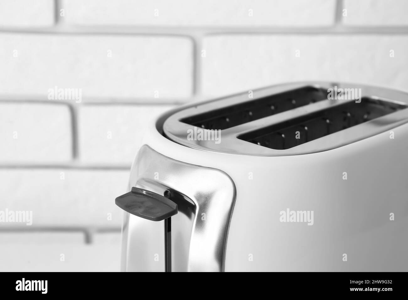 New modern toaster on light brick background, closeup Stock Photo - Alamy