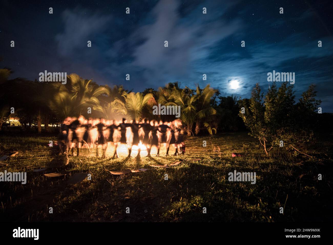 A beautiful shot of people dancing around a campfire, under the ...