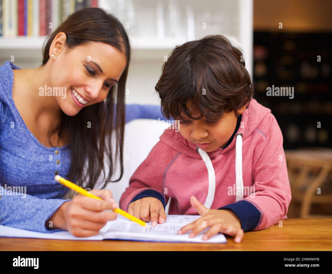 Learning with love. Shot of a mother helping her son with his homework Stock Photo - Alamy
