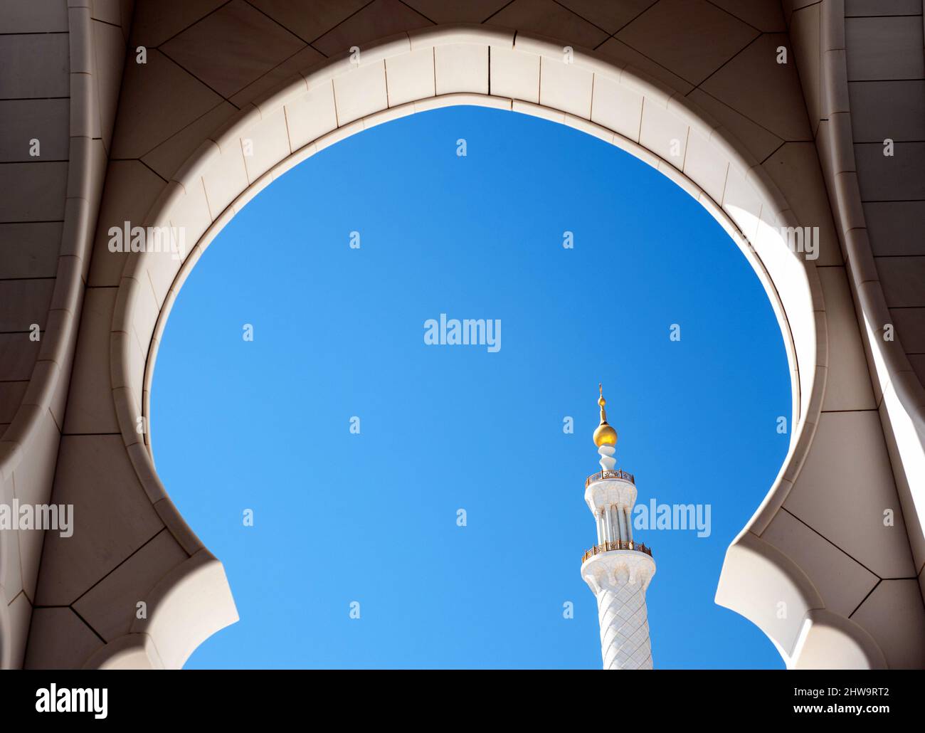 Keyhole arch of the Sheikh Zayed Grand Mosque in Abu Dhabi against a ...