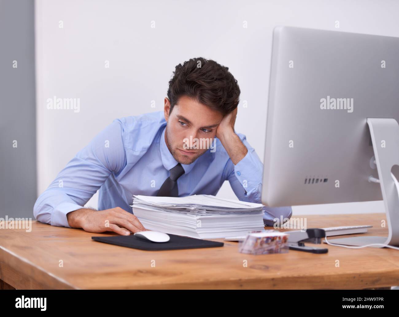 Work getting you down. Shot of a tired looking office worker sitting at ...