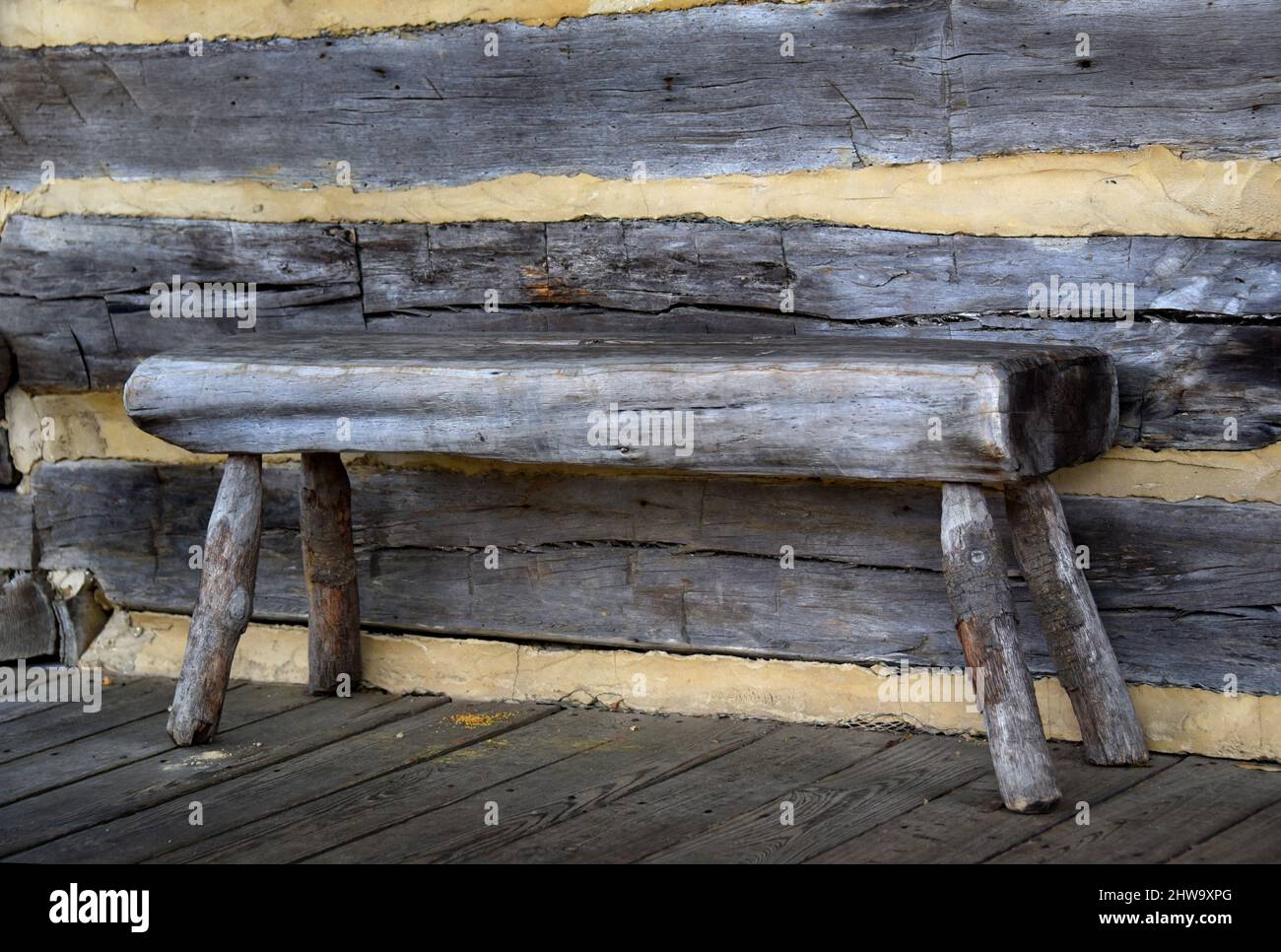 Bench seat, built of a hewn log, sits on the porch of the stage coach ...