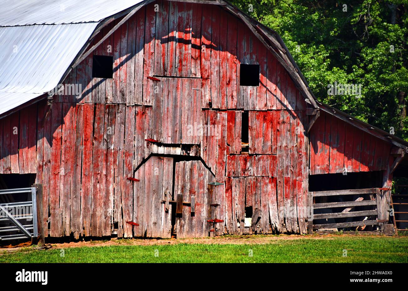 Closeup of the front of this old, red wooden barn, shows broken and ...