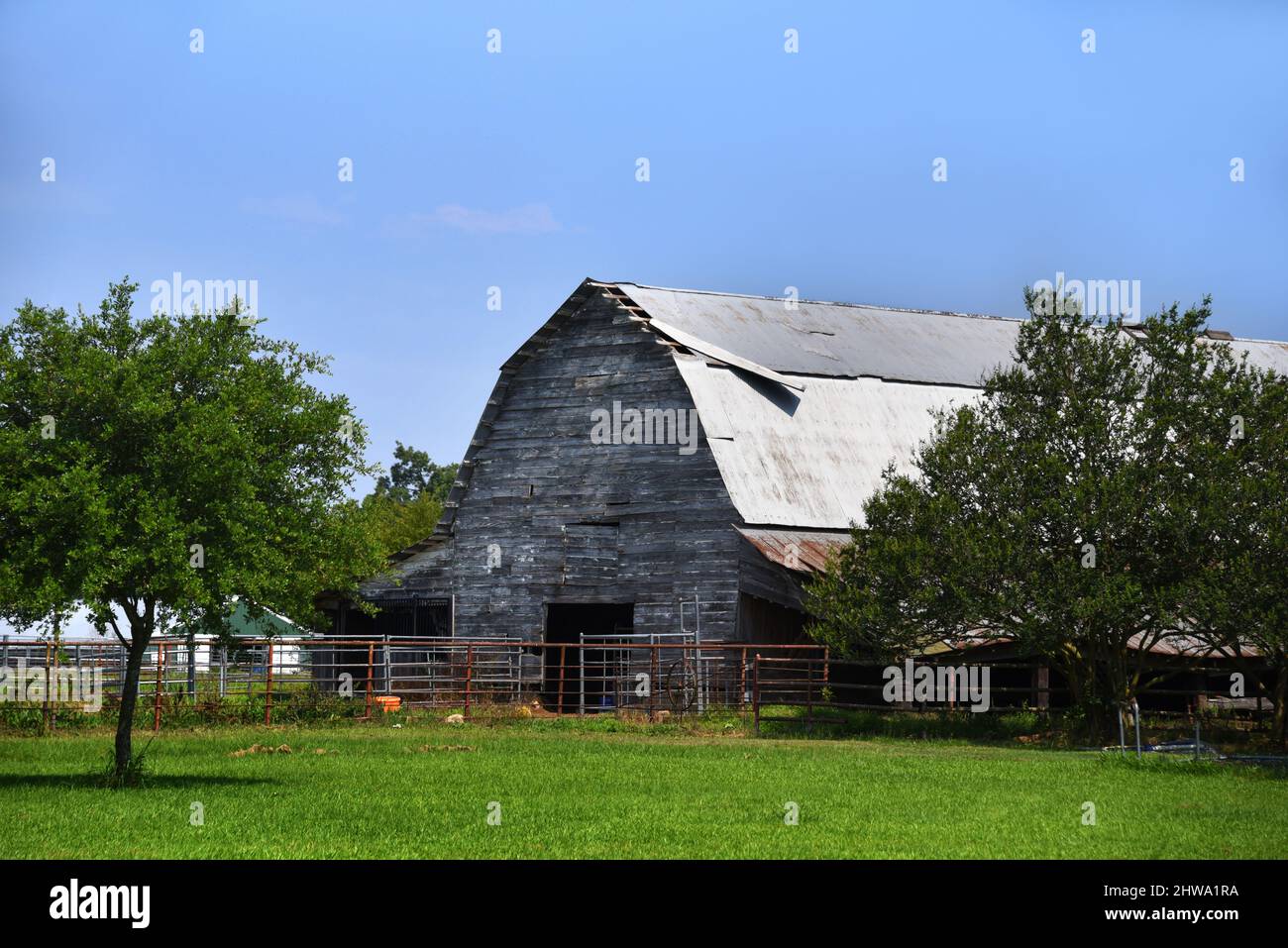 Rustic, wooden barn is weathered with age. All paint has faded or ...