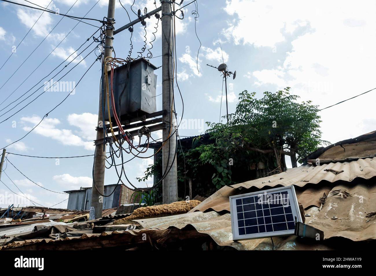 A solar powered lamp charging close by a local Kenya power transformer ...