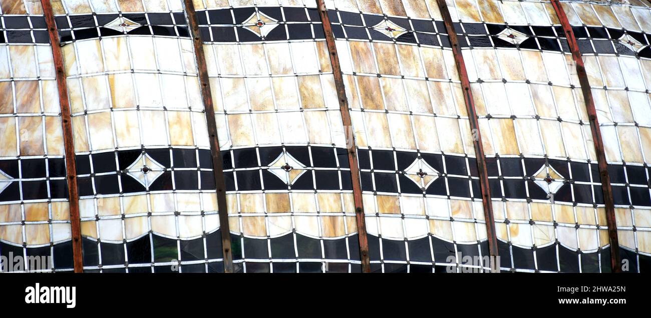 Old stained glass canopy has metal bands holding it together. Black ...
