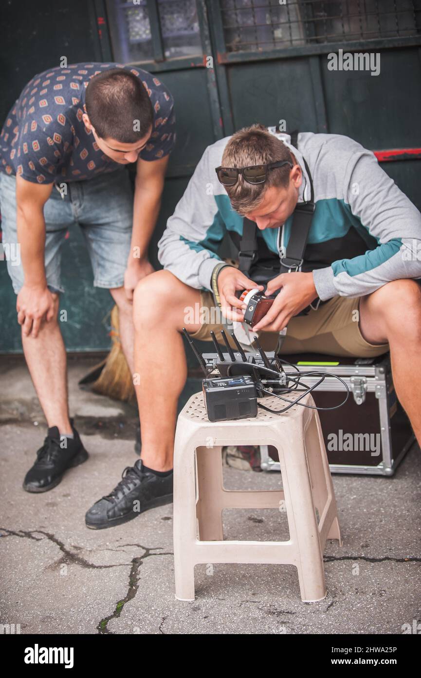 Behind the scenes. First assistant focus puller helps the cameraman ...