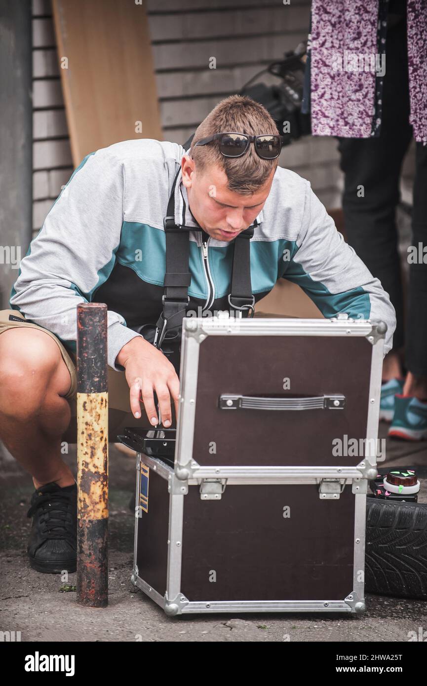 Behind the scenes. First assistant focus puller helps the cameraman ...