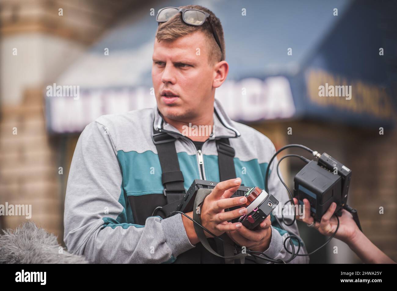 Behind the scenes. First assistant focus puller helps the cameraman ...