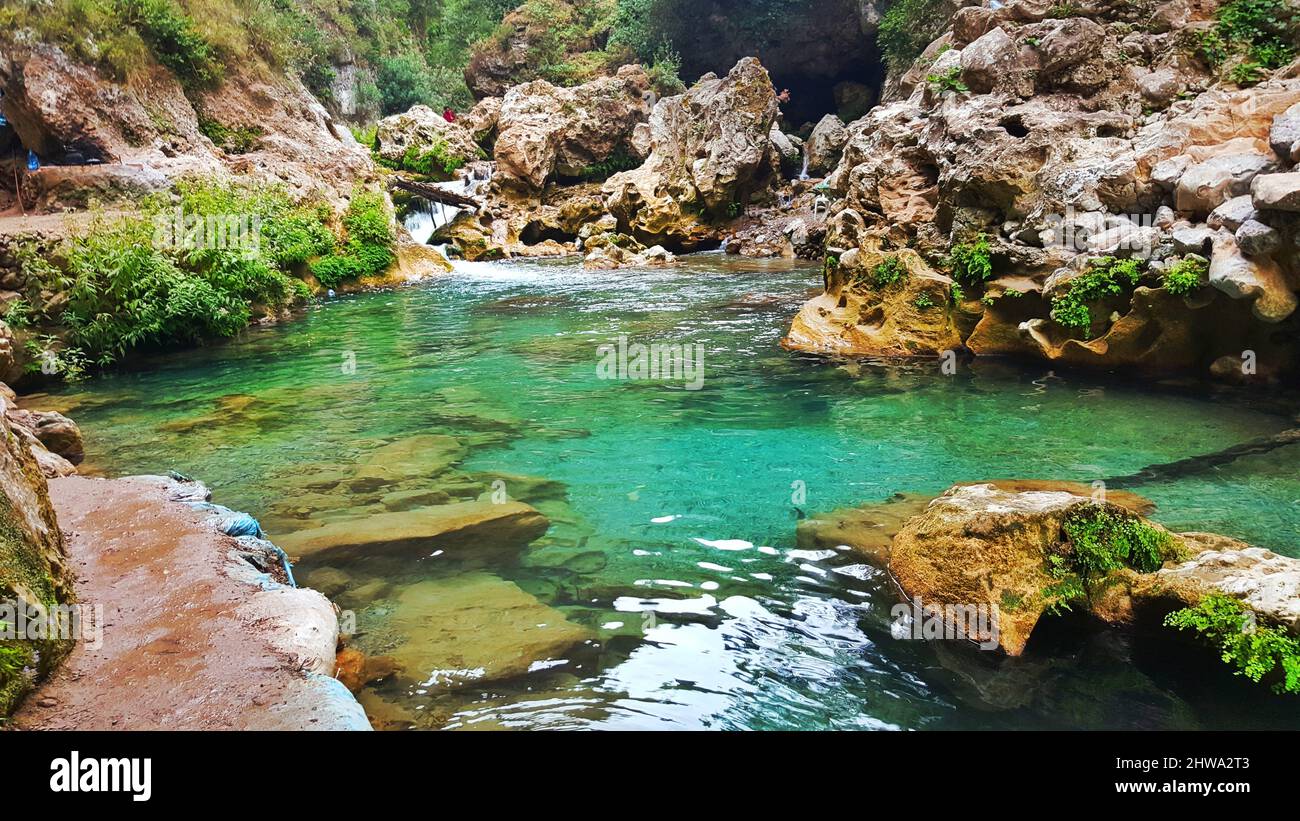 Scenic view of the transparent river flowing through the mossy rocks ...
