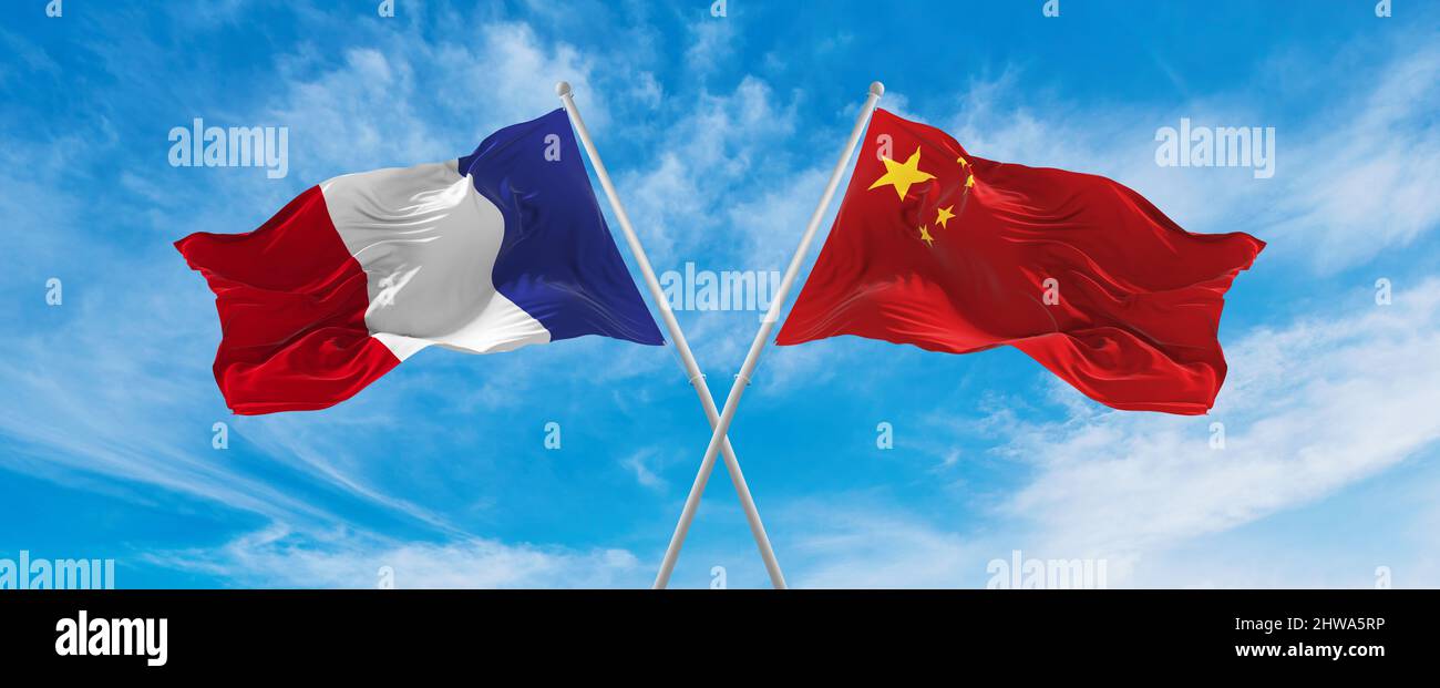 crossed national flags of France and china flag waving in the wind at ...
