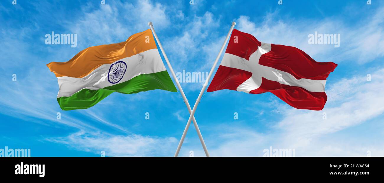 crossed national flags of India and denmark flag waving in the wind at ...