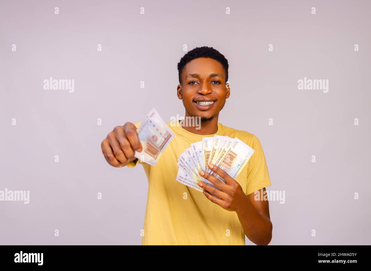 young african boy isolated over white background giving out money Stock ...