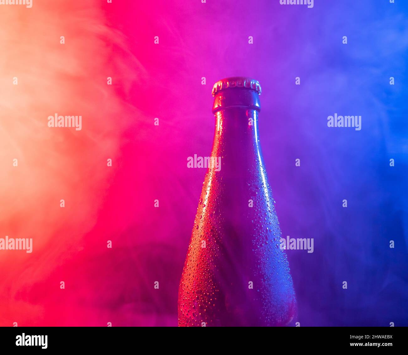 Glass bottle of beer in blue pink mist Stock Photo - Alamy