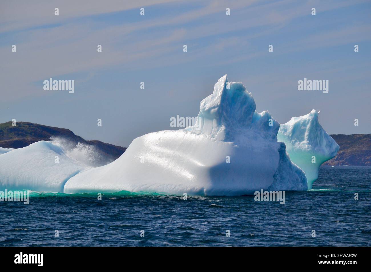 Waves crashing against large iceberg in bay outside St. John's during ...