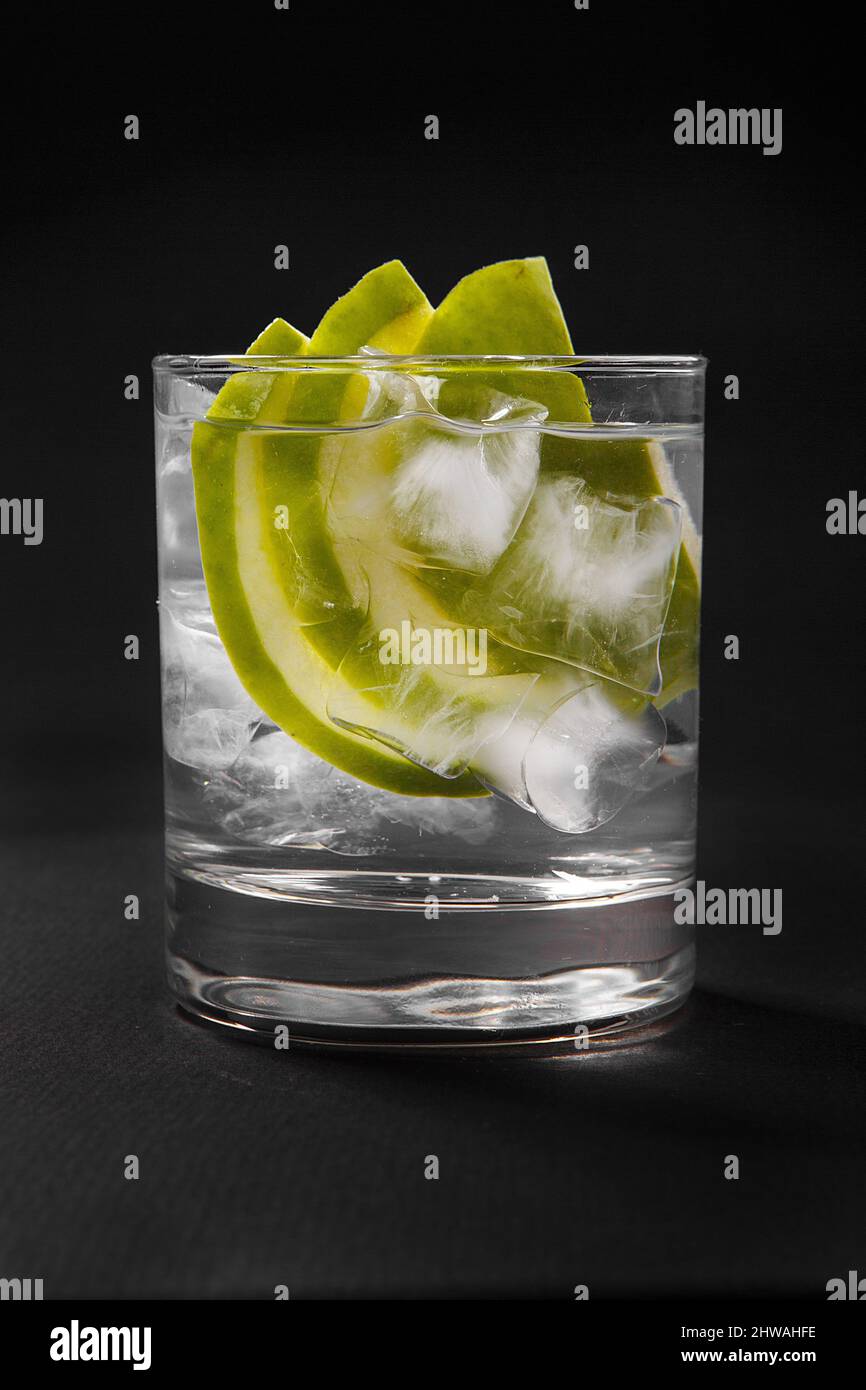 Transparent cocktail, refreshing water in a low glass with ice cubes ...