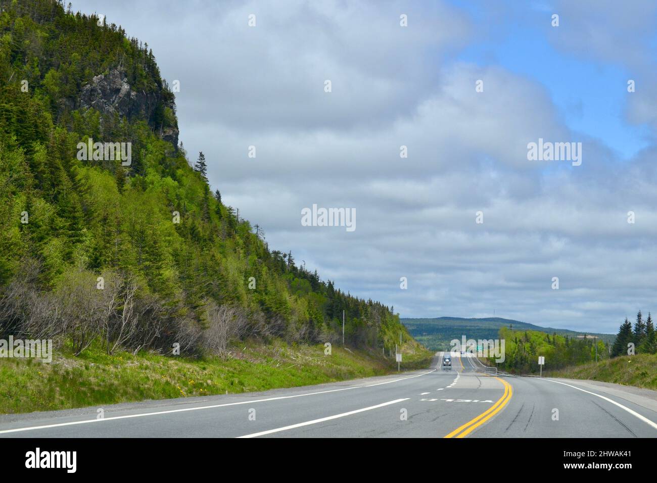 Scenic hilly landscape and cloud filled sky along Newfoundland highway ...