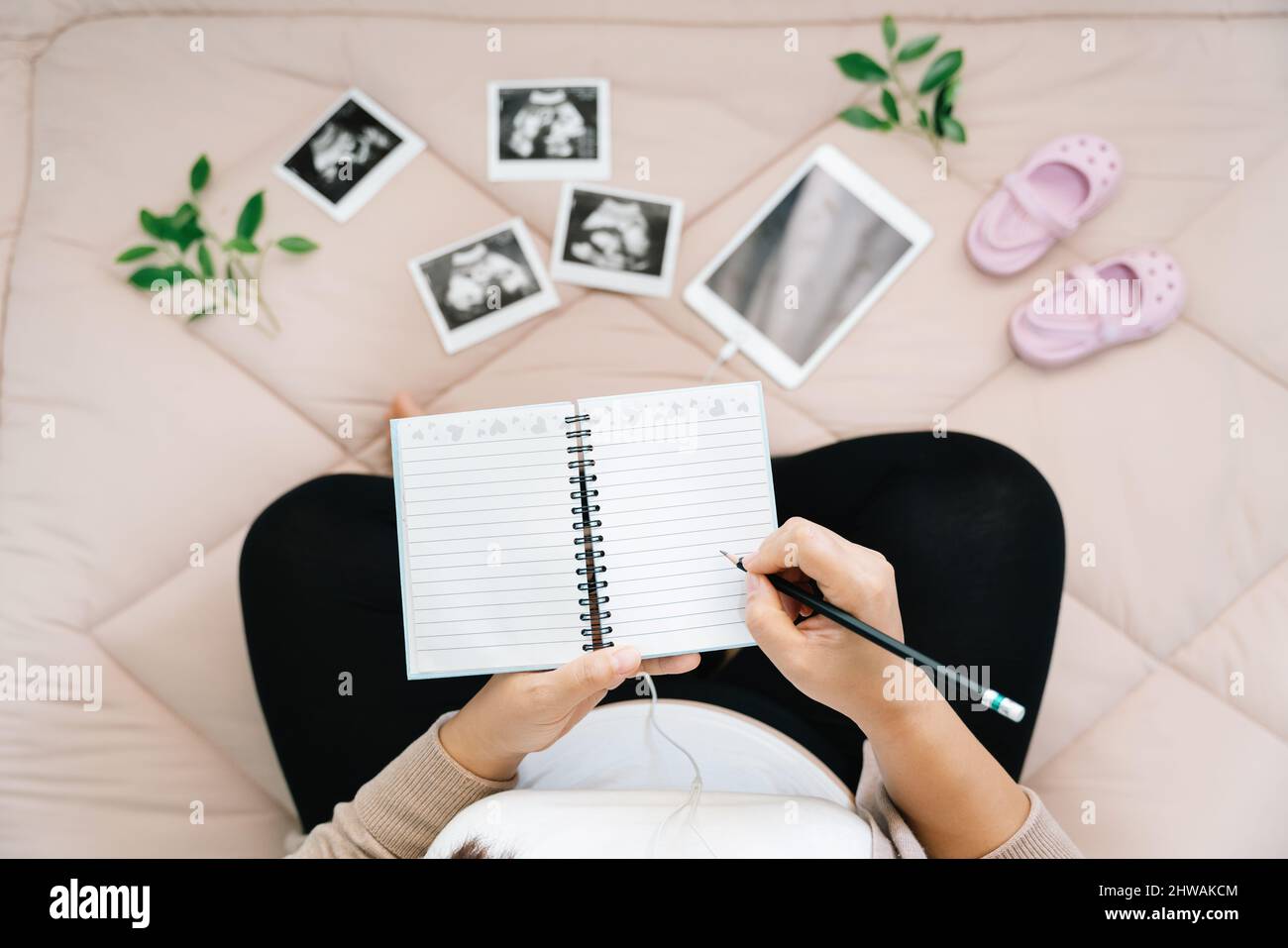 A Pregnancy dairy.Top view of pregnant woman writing thoughts down in ...