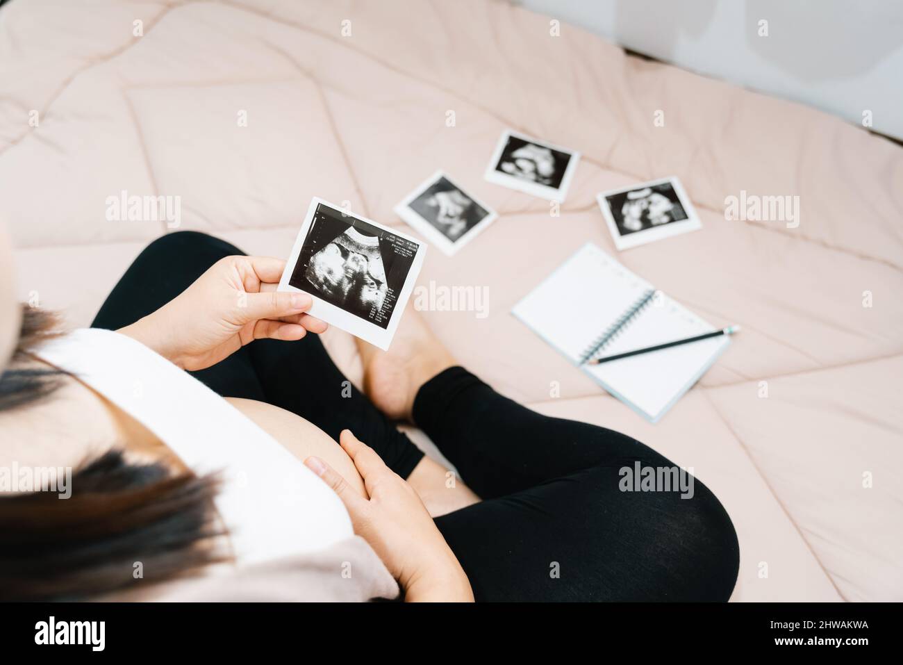 A cute pregnant belly and x ray ultrasound scan of baby. asian young ...