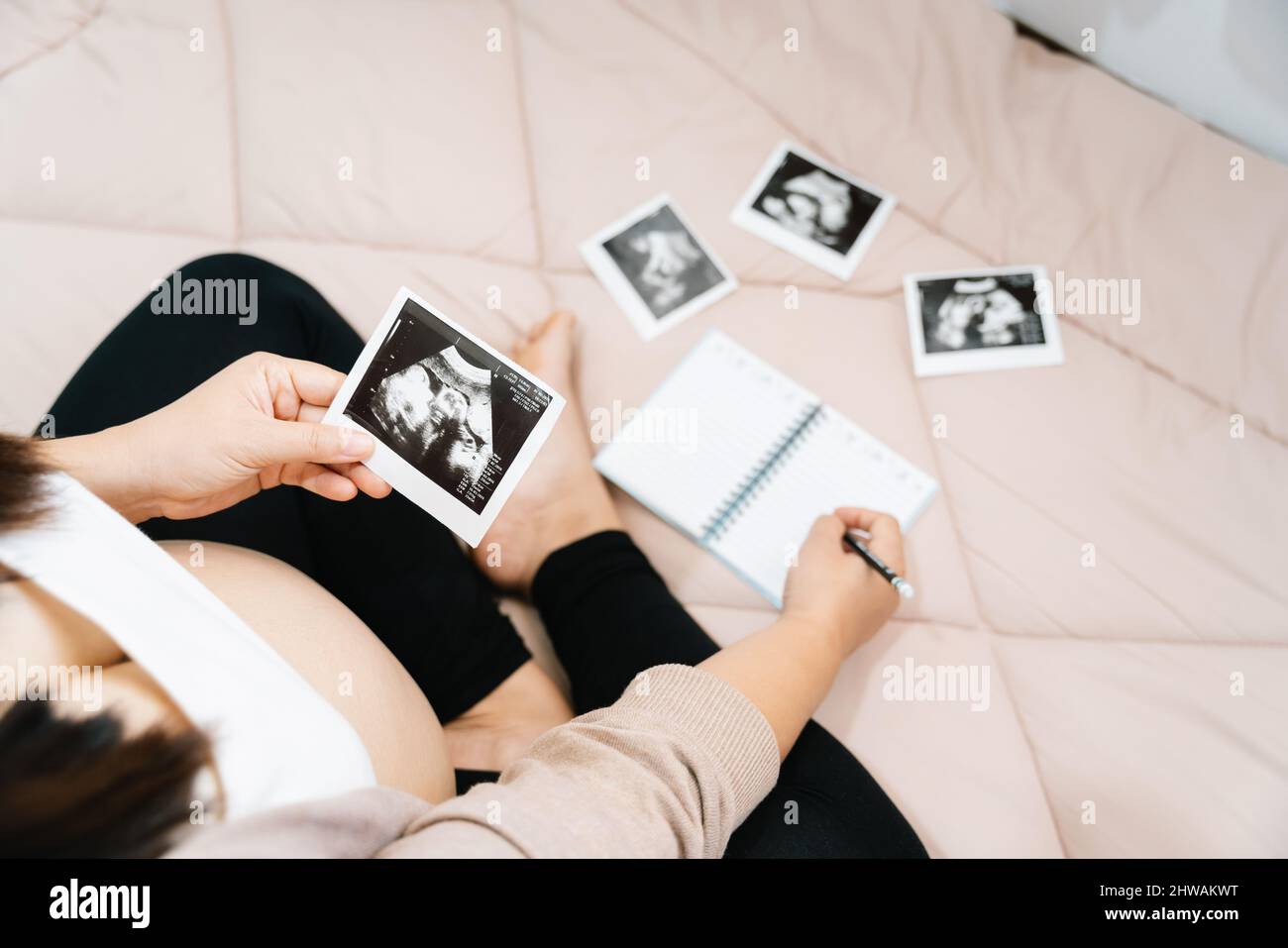 A Pregnancy dairy.Top view of pregnant woman writing thoughts down in ...