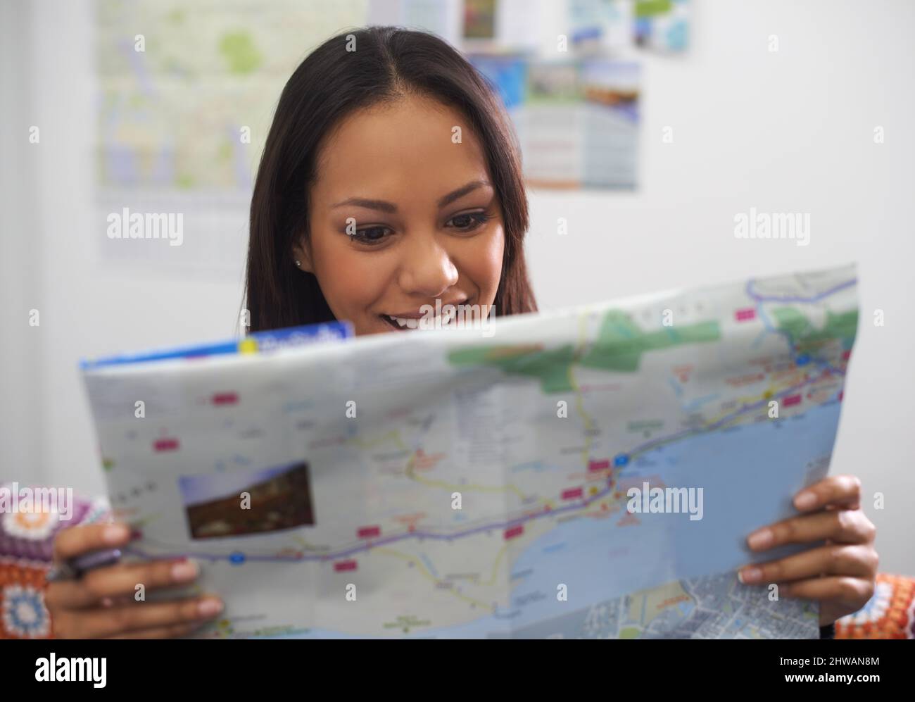 Planning her next vacation. A young woman reading a map Stock Photo - Alamy