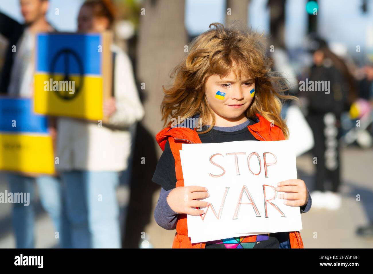Young child in a protest with ukrainian flag and poster Stop war. Kids ...