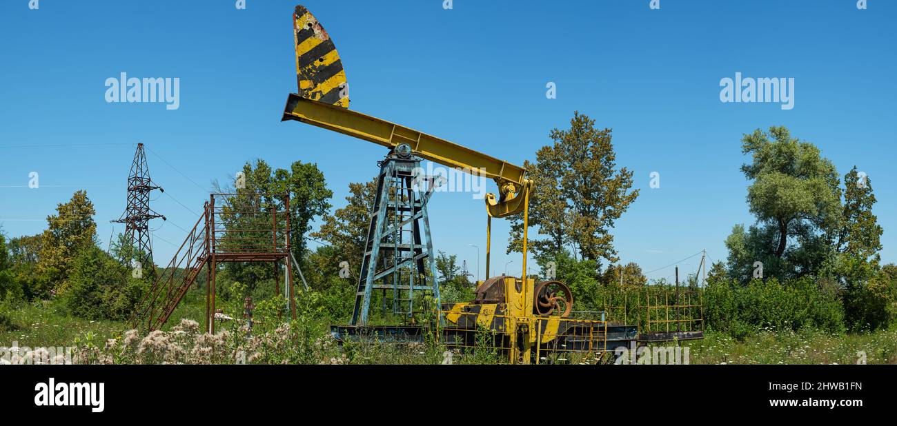 An old abandoned yellow oil rig with a rusty ladder against a ...