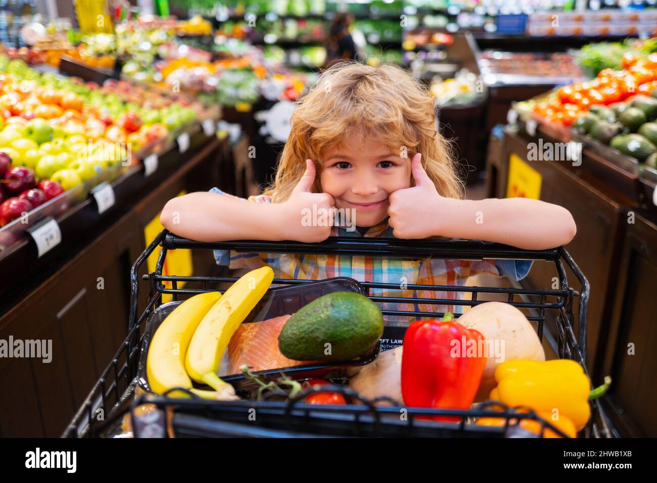 Child shopping in supermarket. Kid boy is shopping in a supermarket ...