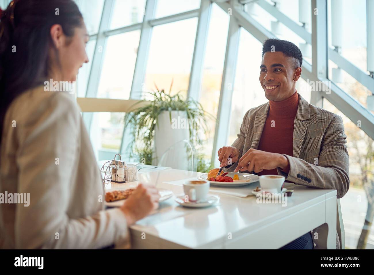 A young businessman is enjoying a lunch break in a relaxed atmosphere ...