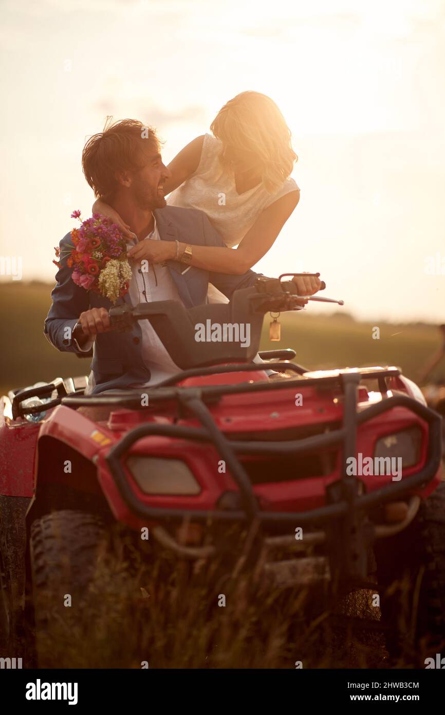 Romantic young wedding couple at sunset drive quad atv vehicle Stock ...