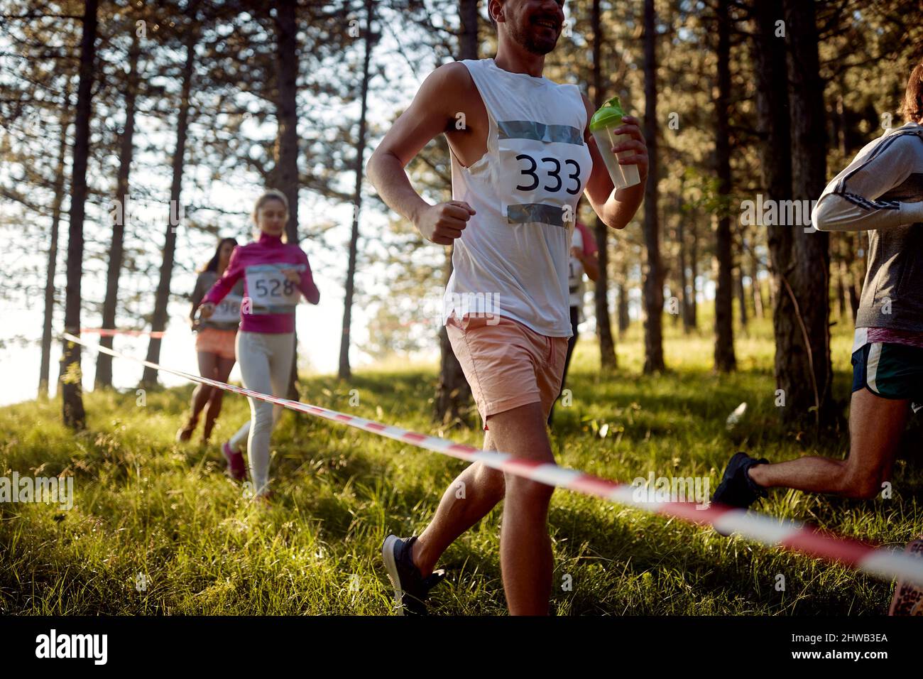 Group of athletes running through forest. Marathon in the forest. Sport ...