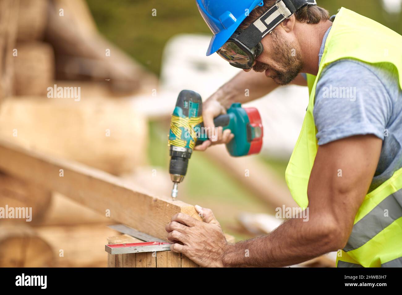 Close-up of handsome male builder working with tools at the ...