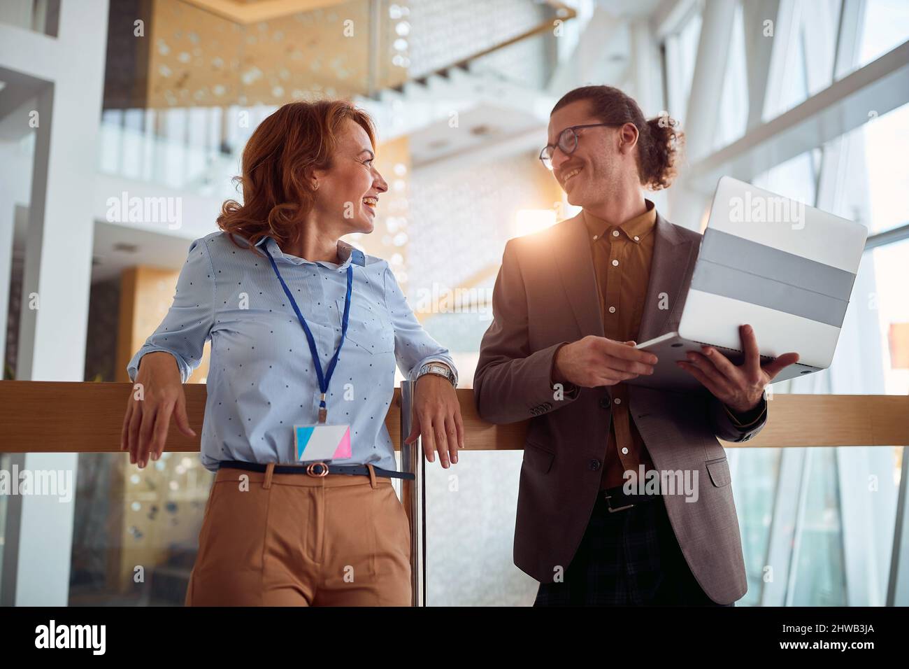 Business smiling people talking at hallway and working on computer ...