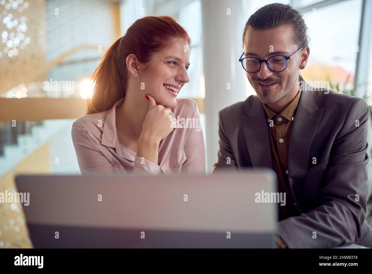 Two young business colleagues in a friendly atmosphere at the office ...