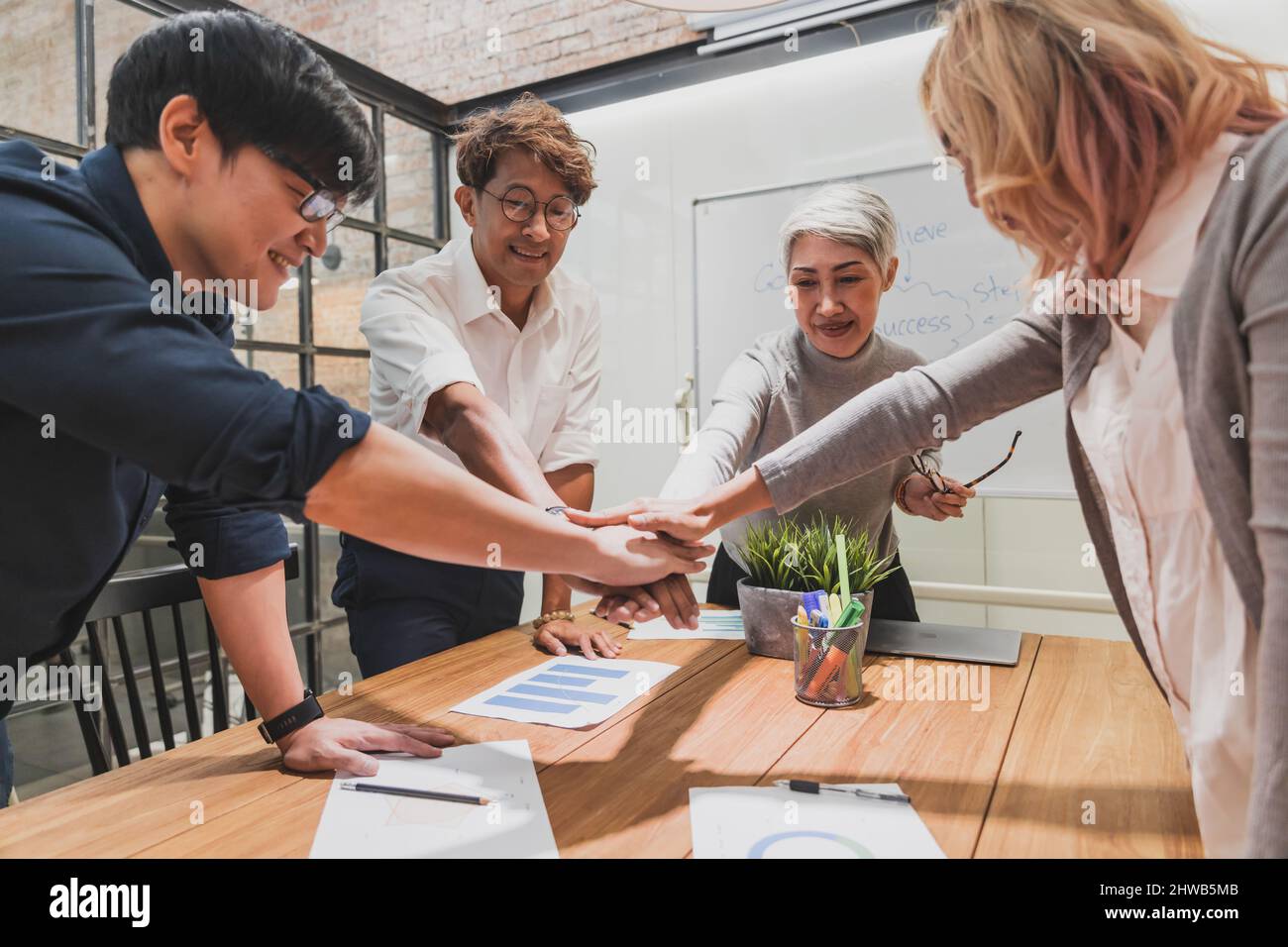 Business people team put hand up group together for unity and cooperate ...