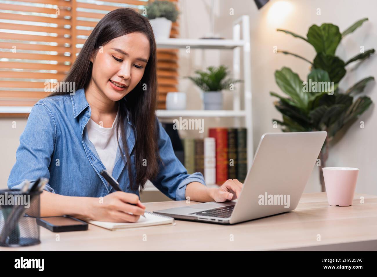 Asian beautiful woman looking at laptop and writing, student woman ...